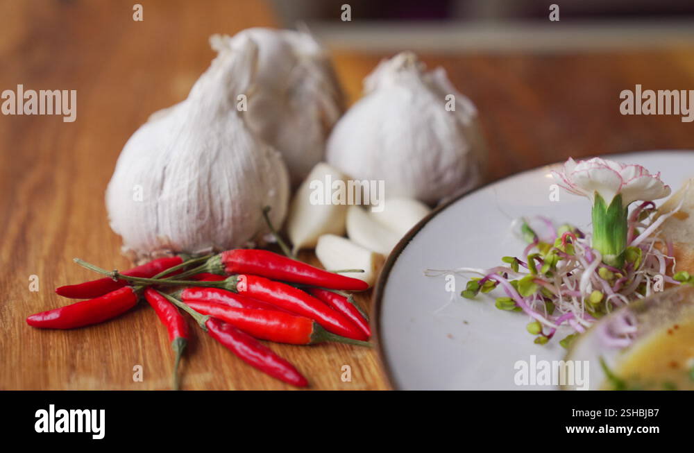 Whole head of garlic and small red chili peppers. Restaurant cuisine ...
