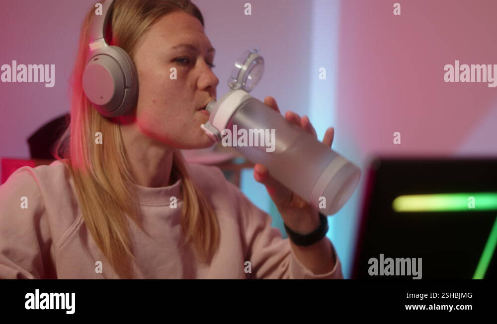 Girl gamer drink water during online game. young woman takes couple of ...