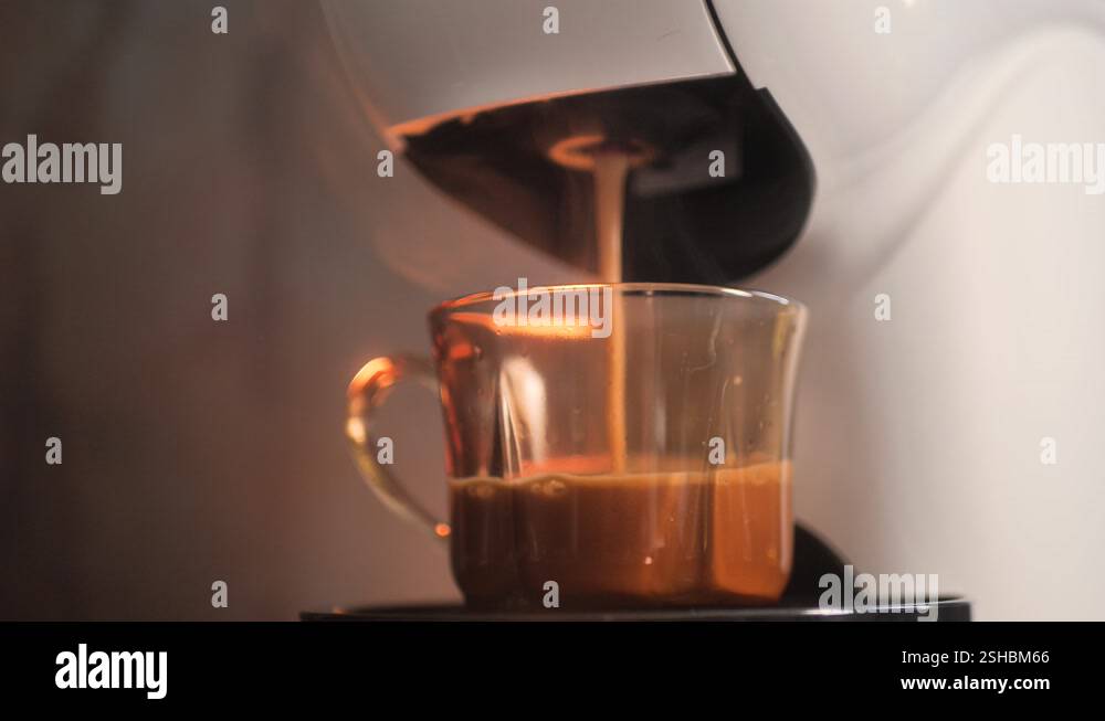 Process of making espresso coffee by coffee machine into a glass cup ...