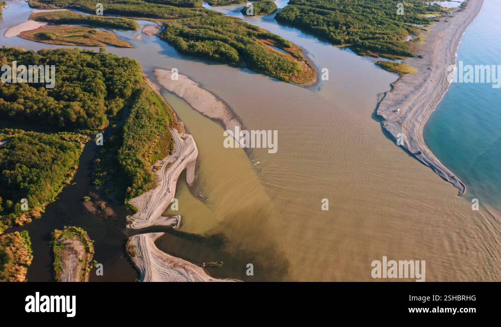 Flying above mountain river with small straits and islands on delta ...