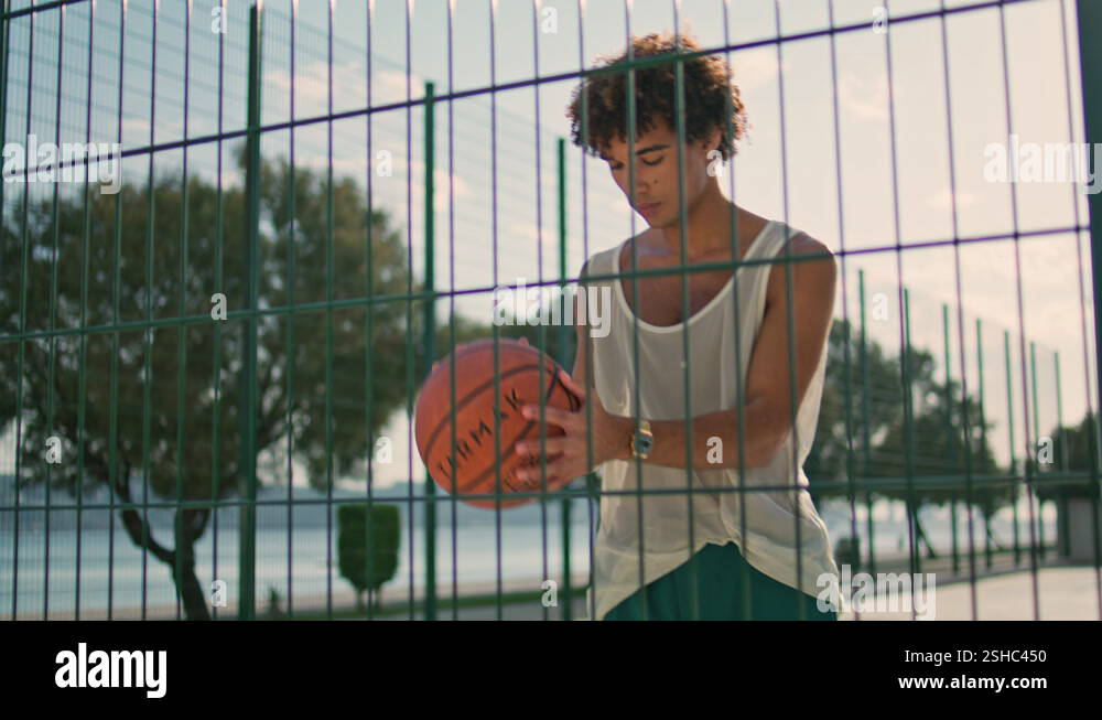 Basketball player training stadium zoom out. Curly hair man playing ...