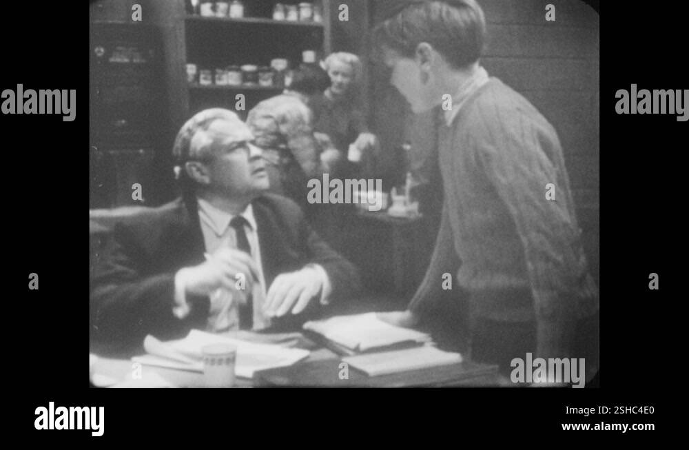 1960s: People sit, talk and wait in a basement shelter. A young woman ...