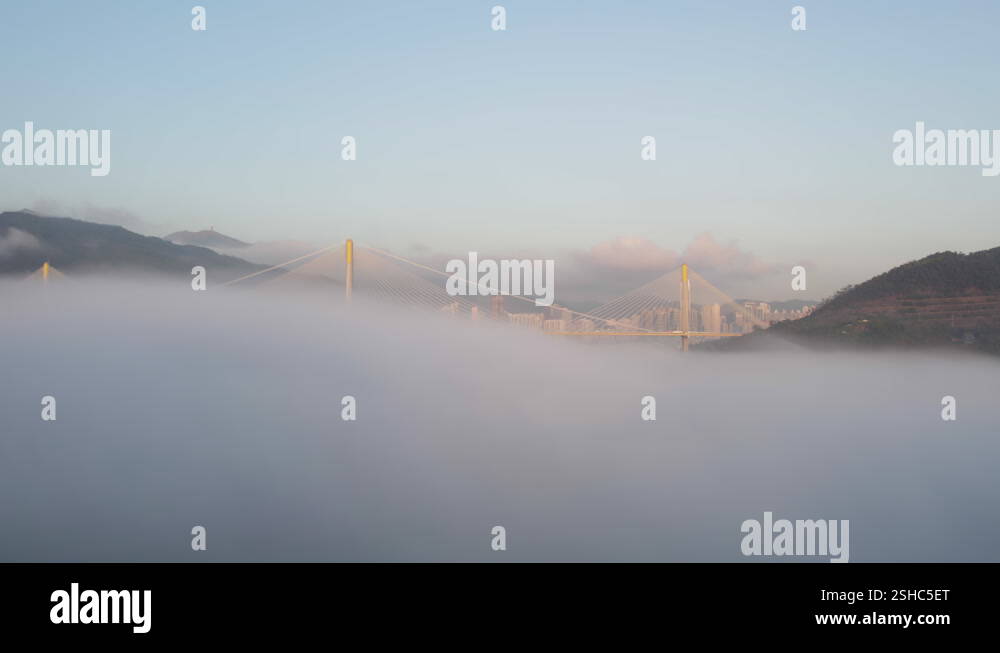 Foggy morning with sun rays shining through Ting Kau Bridge in Hong ...