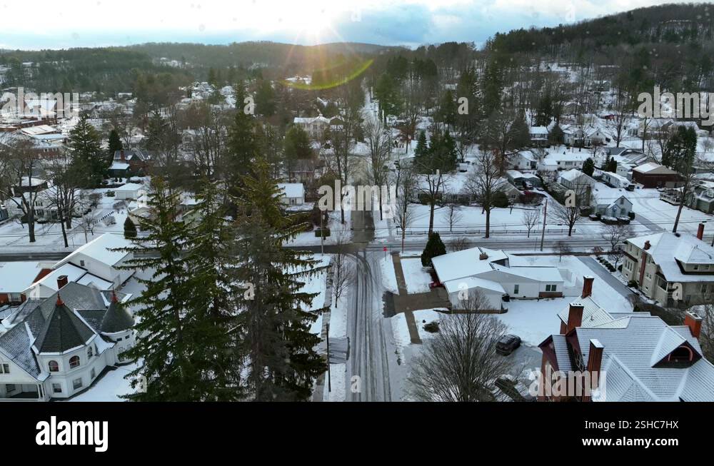 Aerial descending shot of snow falling on quaint neighborhood in ...