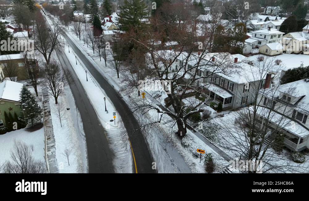 Slow aerial tilt up reveal of snowy ski town in winter after snow storm ...