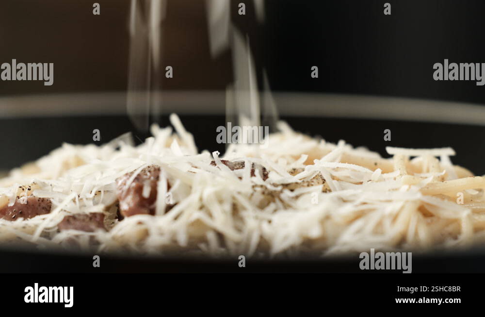 Carbonara recipe; Sprinkle grated parmesan cheese over cooked dish ...