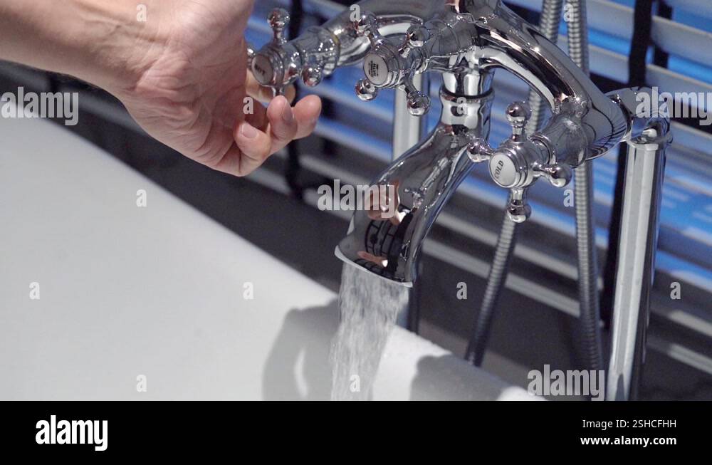 Person Hand Turning On Water Faucet Of A Luxury Bath Tub. Static Close ...