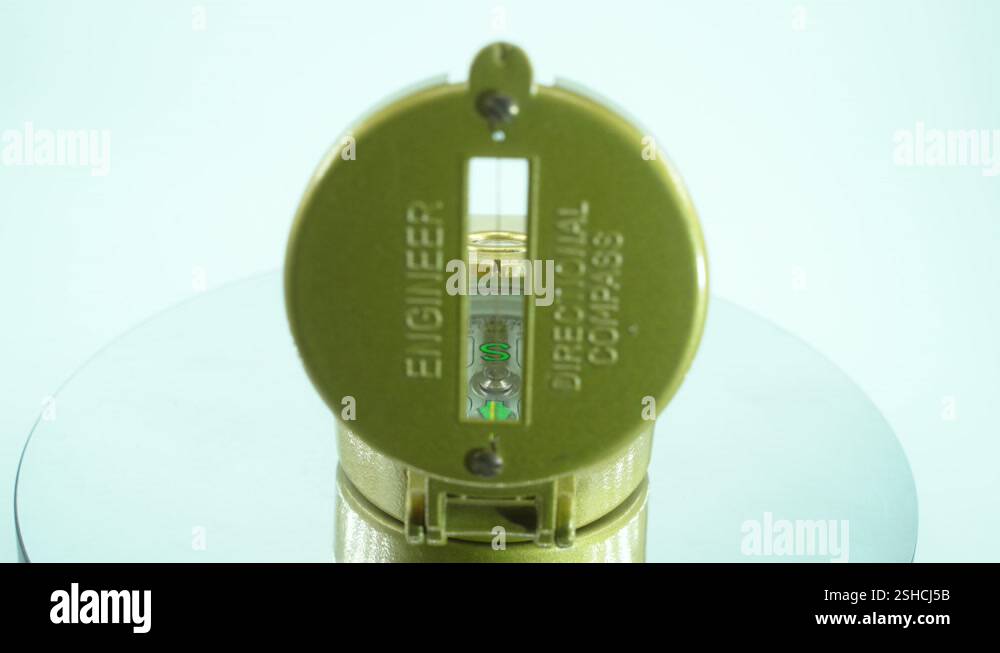 A close up shot of a golden retro opened compass on a reflecting ...