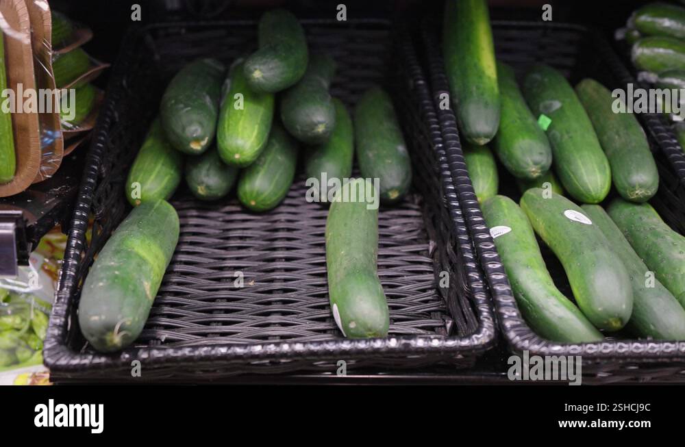 Fresh cucumbers on display in a grocery store. Cucumbers in a produce ...