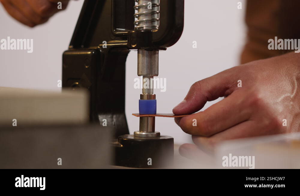 Master installs rivet in leather with machine in workshop Stock Video ...