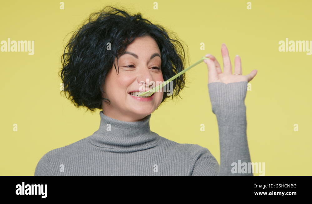 Playful mature woman chewing bubble gum, pulling it out of teeth with ...