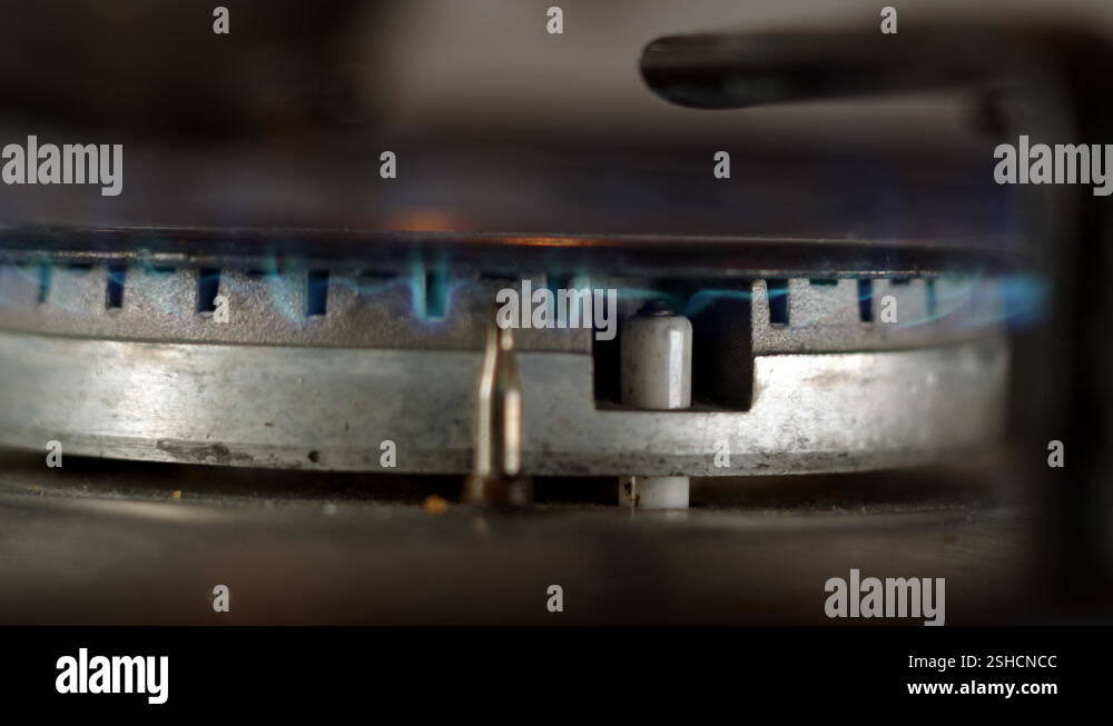extreme close up view of turning on gas stove, spark ignites fire. man ...