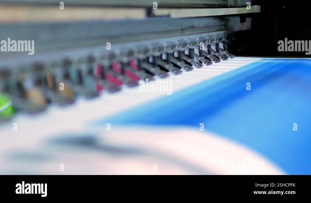 A large-format inkjet printer prints a blue background on a chromakey ...