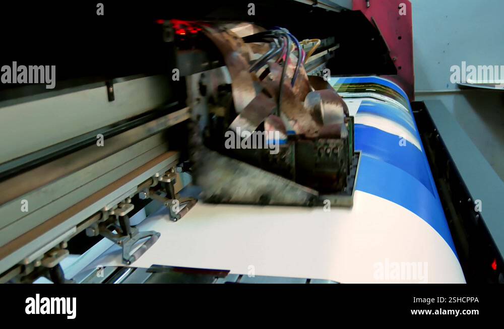 The printhead of a large-format inkjet printer moves along the banner ...