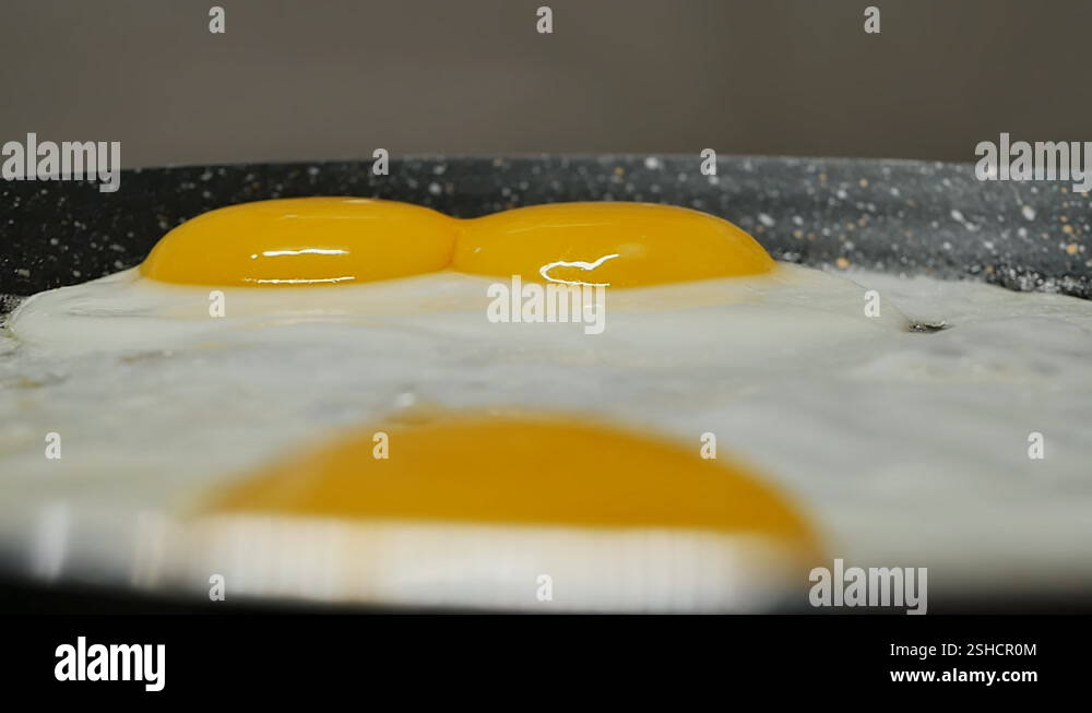 Close-up frying eggs in a frying pan. Close-up frying an egg with a double yolk Stock Video ...