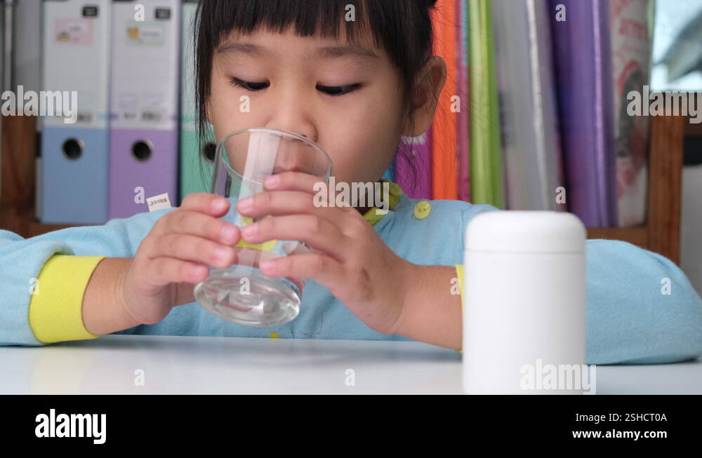 Cute little girl eating alpha omega 3 or Vitamin pill. Vitamin ...