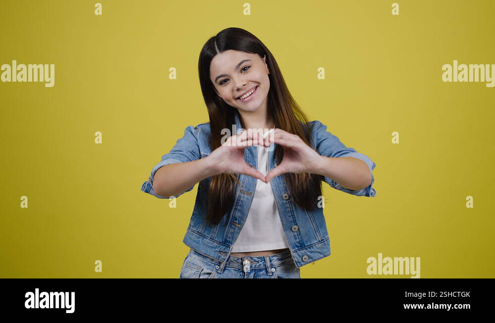 Cute teen girl makes symbol of love, shows heart sign and smiles at ...