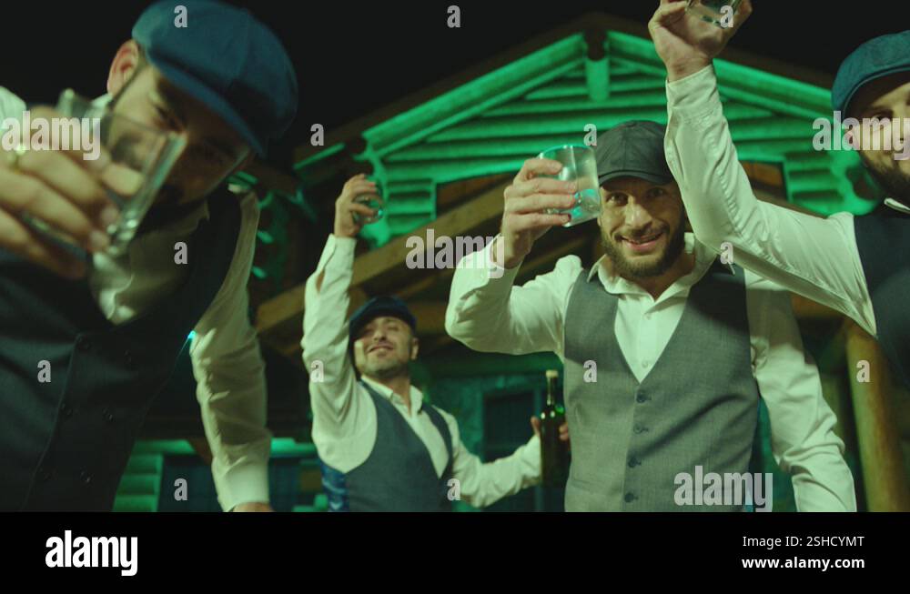 Group of young drunk men drinking alcohol , toasting , cheering ...