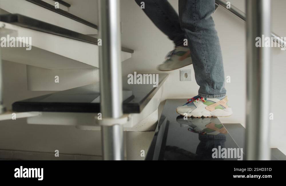 Active woman in sneakers climbing stairs. Closeup of female legs ...