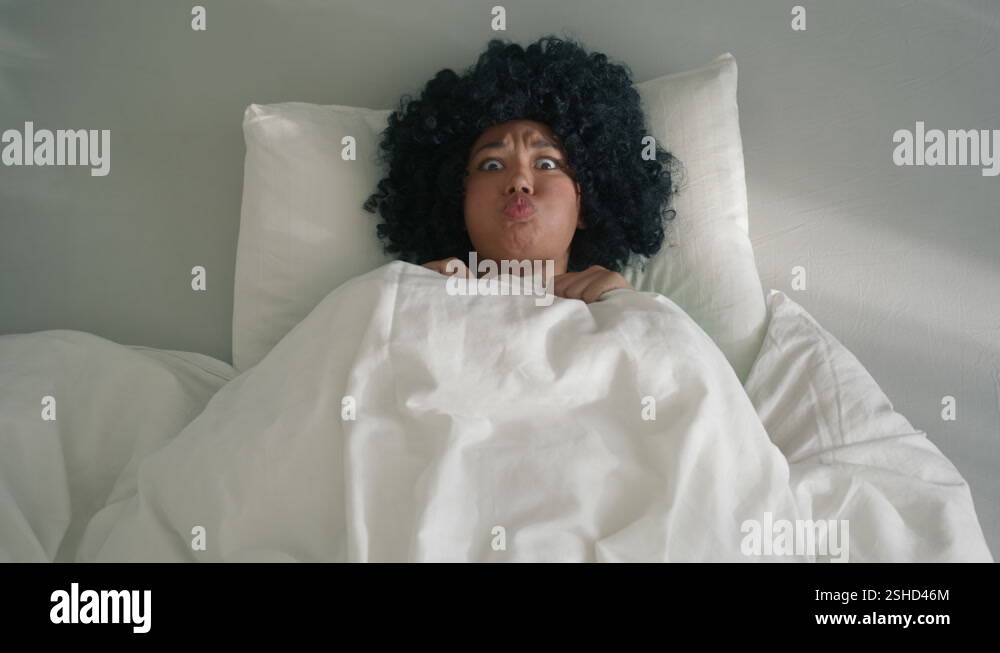 Playful woman of color laughing Making kissy face, looking cross eyed ...