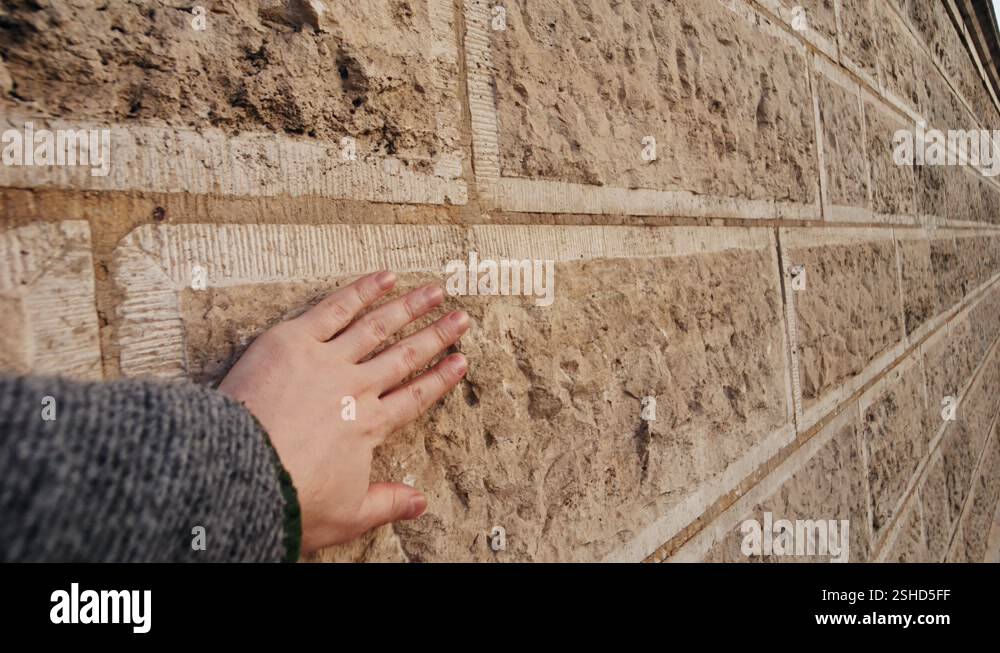 Tourist man hand skin texture on the old wall, male touch the wall of ...