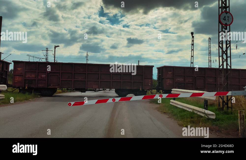 a train passes through a railway crossing with lowered barriers ...