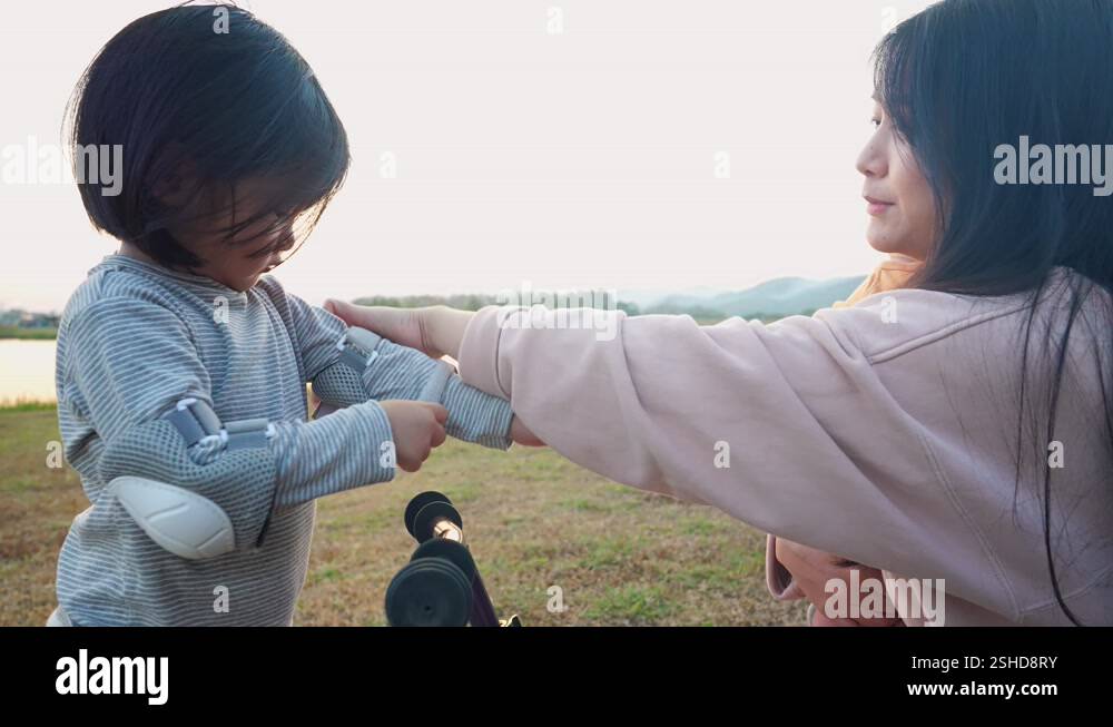 Caring asian multi-tasking mom, helps an adorable daughter wearing ...
