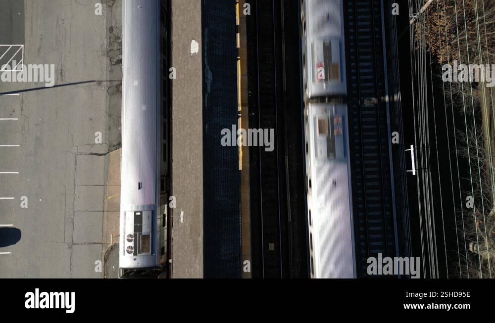 A top down view directly over a train station platform as two trains ...