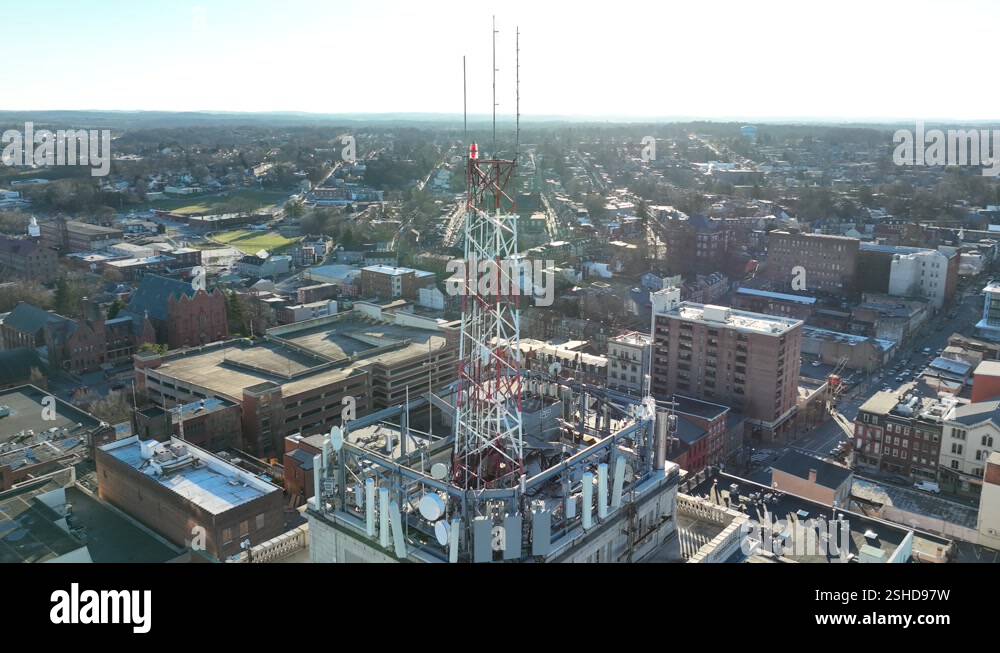 Bright white sunshine during aerial orbit around cell tower on top of ...
