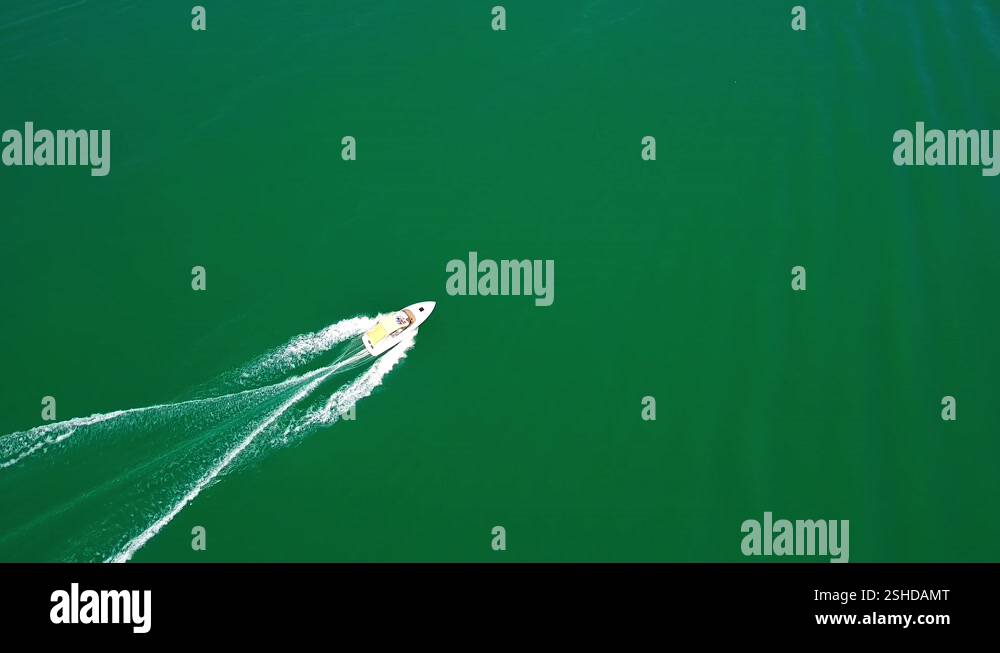Aerial tracking shot of a yacht sailing rapidly forward on the ...