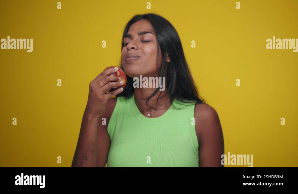 She eating apple with smiling at yellow screen background Stock Video ...