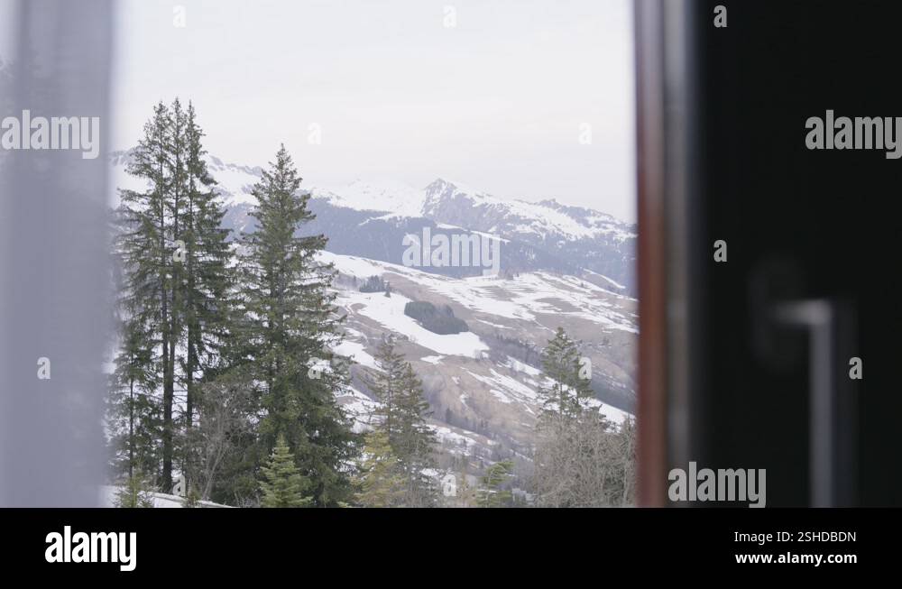 Pull out from view of snowy mountains and trees to hotel or cabin ...