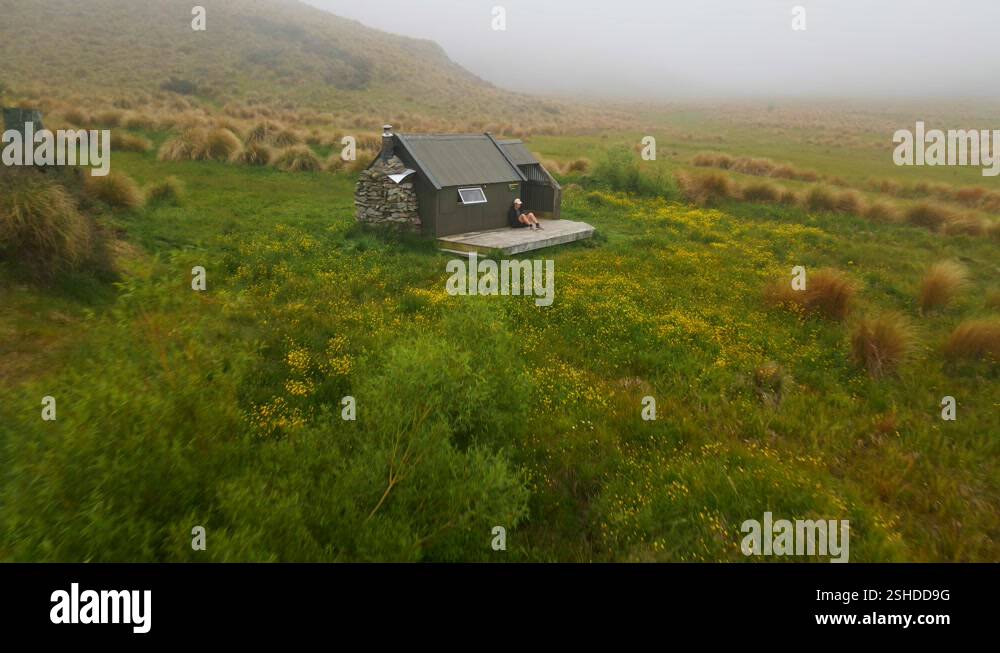 Spurs hut in Mackenzie New Zealand with hiker relaxing on the deck ...