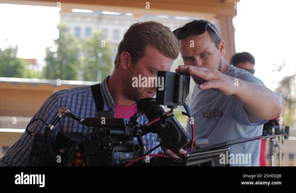 Cameraman with assistant adjusts digital video camera at set Stock ...