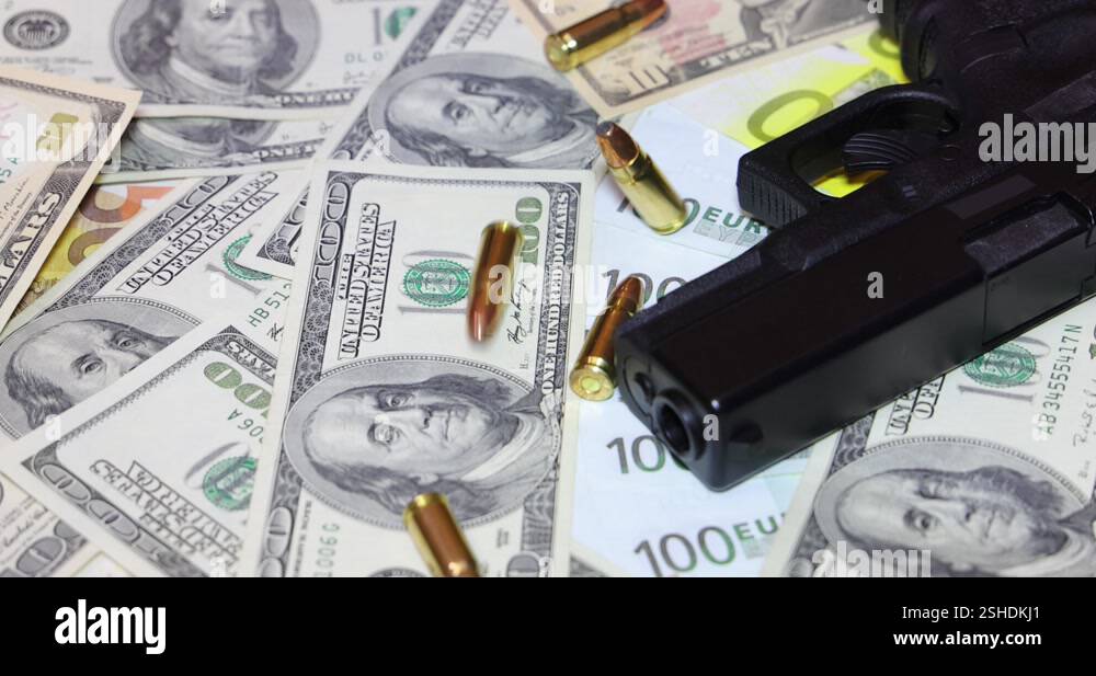 Gun and bullets on dollar and euro banknotes background, slow motion ...