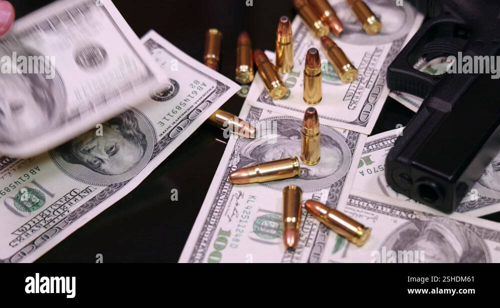 Counting dollar bills, gun and bullets on dollar banknotes background ...
