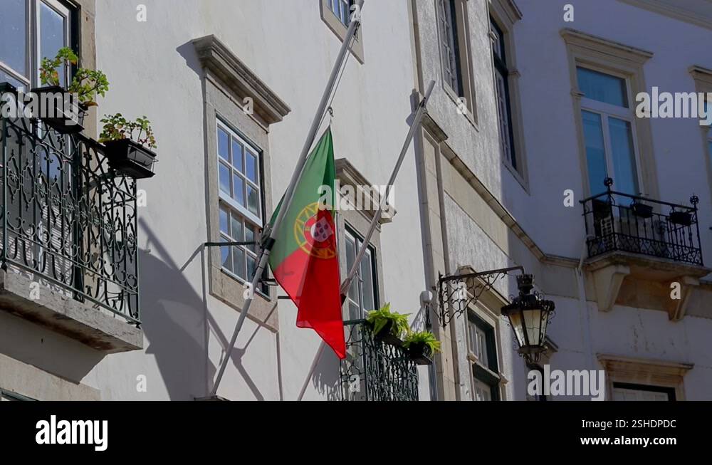 Portuguese flag flying on a building in clear weather. Static low angle ...