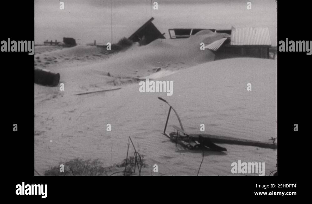 1930s: Dry, barren landscape. Abandoned house buried in mounds of dust ...