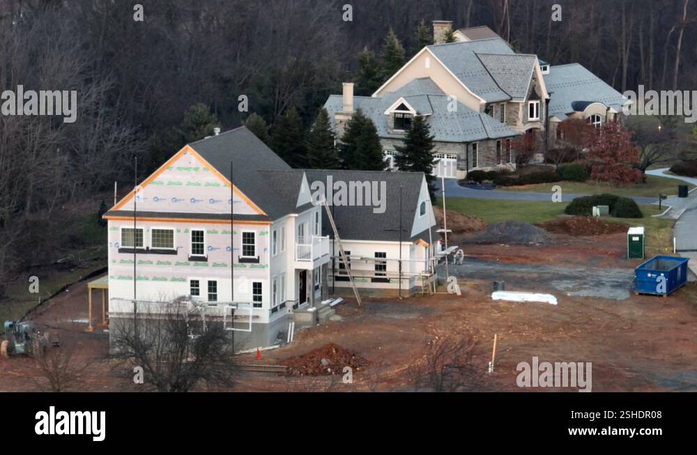 Long aerial zoom of two mansions. American home under construction ...