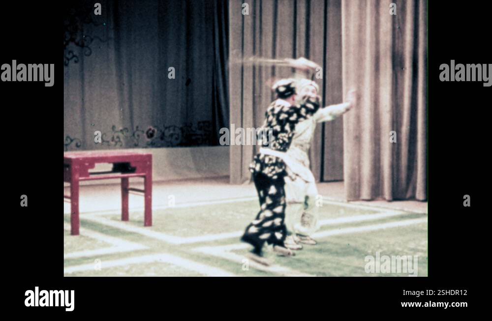 1950s: Peking Opera stage. Man in pajamas and actor fight each other ...