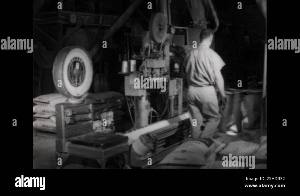 1950s: Worker stacks sacks of chicken feed in plant. Family eats at ...