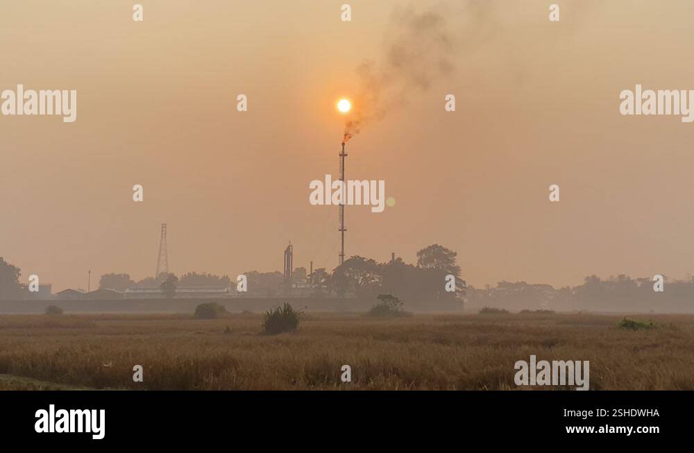 Establisher wide shot of hazy sunset with Gas Tower Plant burning ...