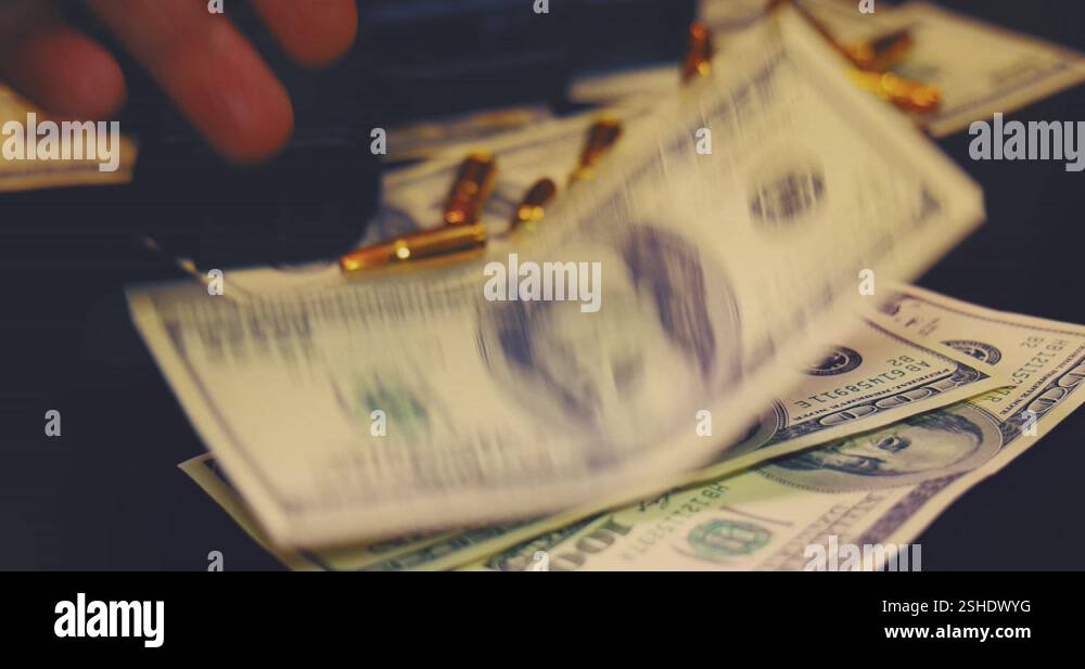 Counting dollar bills, gun and bullets on dollar banknotes background ...