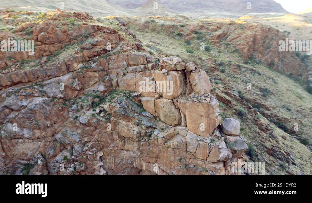 Cinematic aerial view circling kissing rocks in a lush desert gorge ...