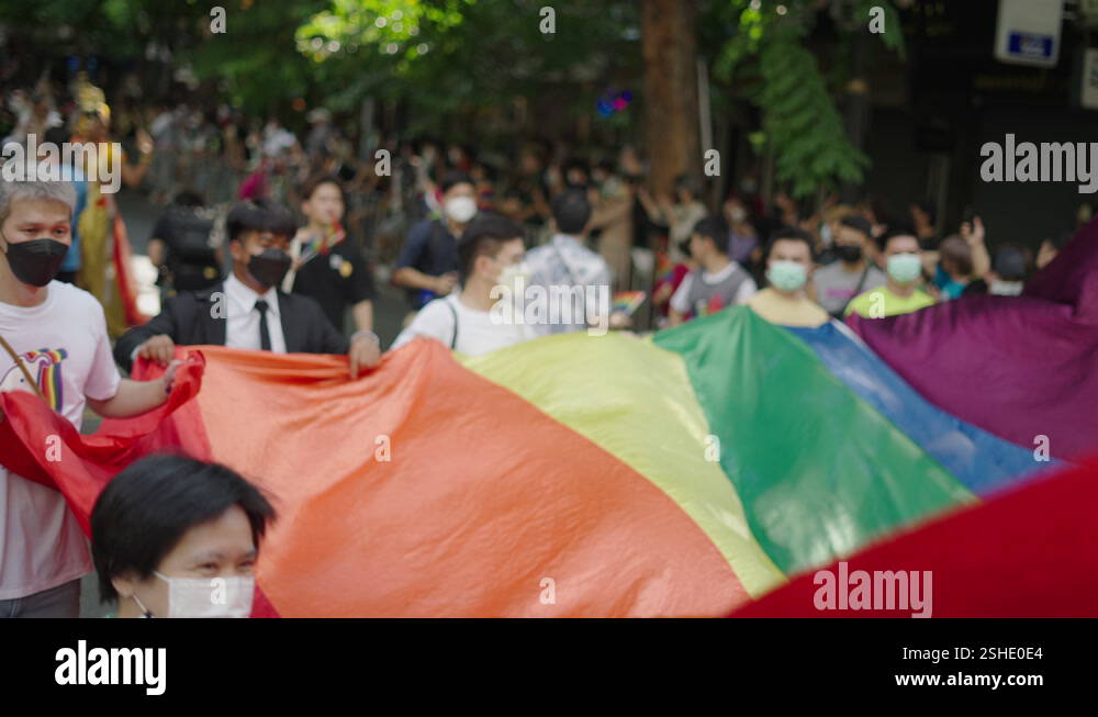 Group Of People Waving Giant Pride Flag In The Street Supporting LGBTIQ ...