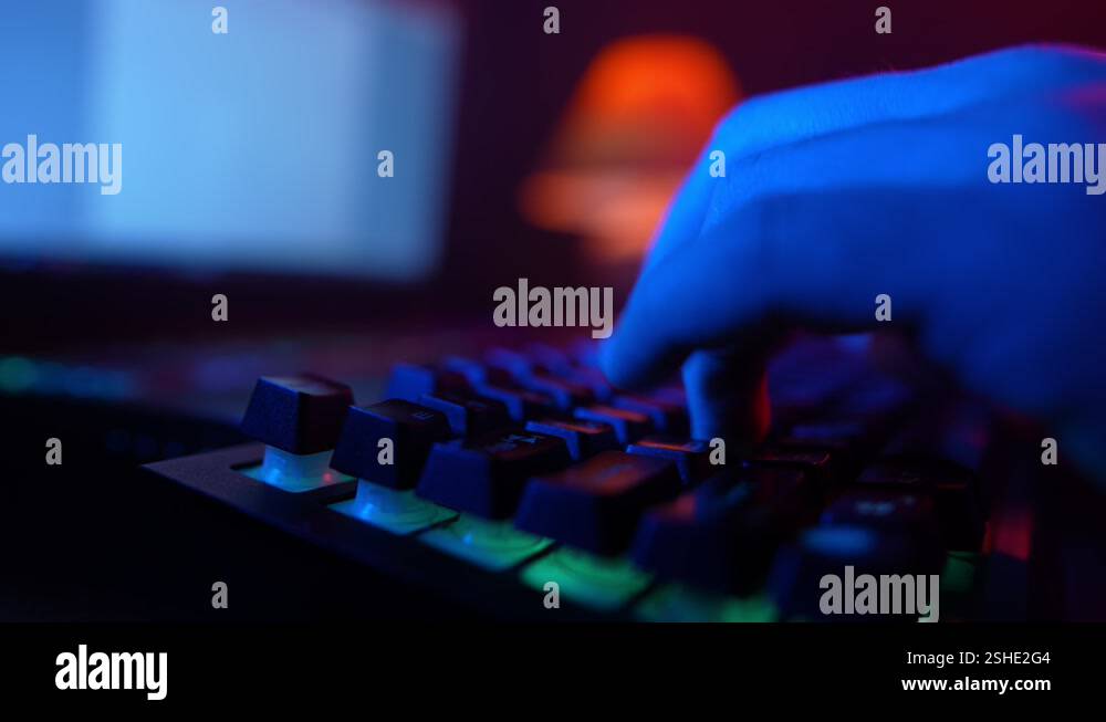 Man Using Computer Keyboard Code Website in Neon Lighting. Hacker and ...