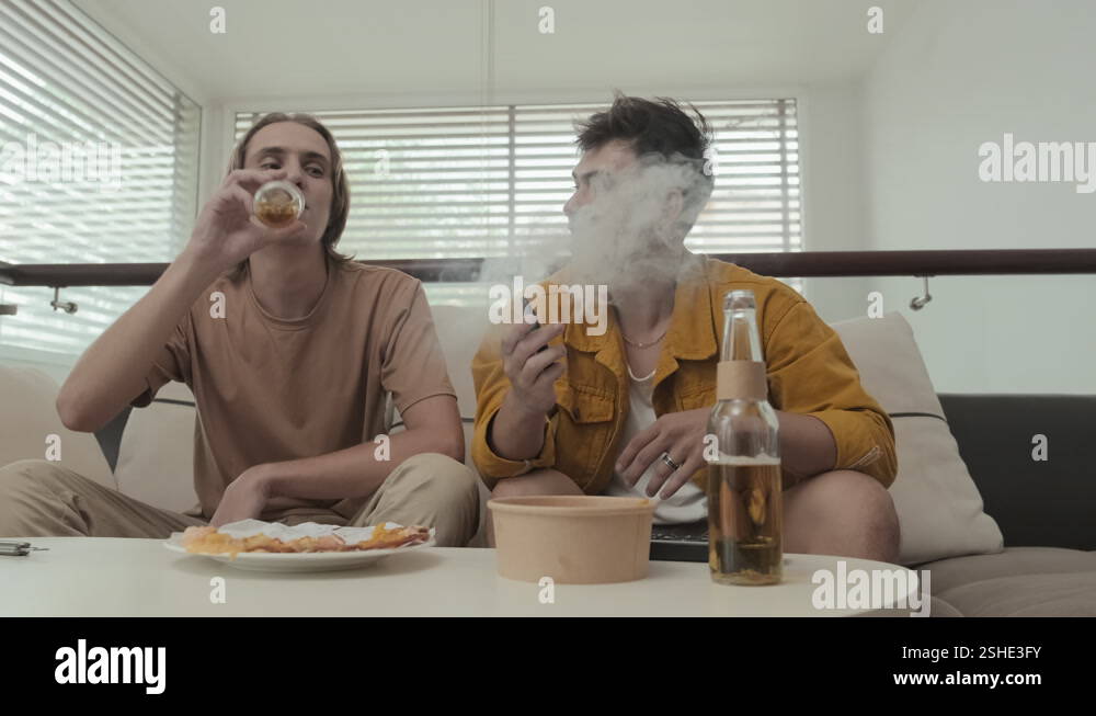 Guy Vaping and Drinking Beer with Friend at Home Stock Video Footage ...