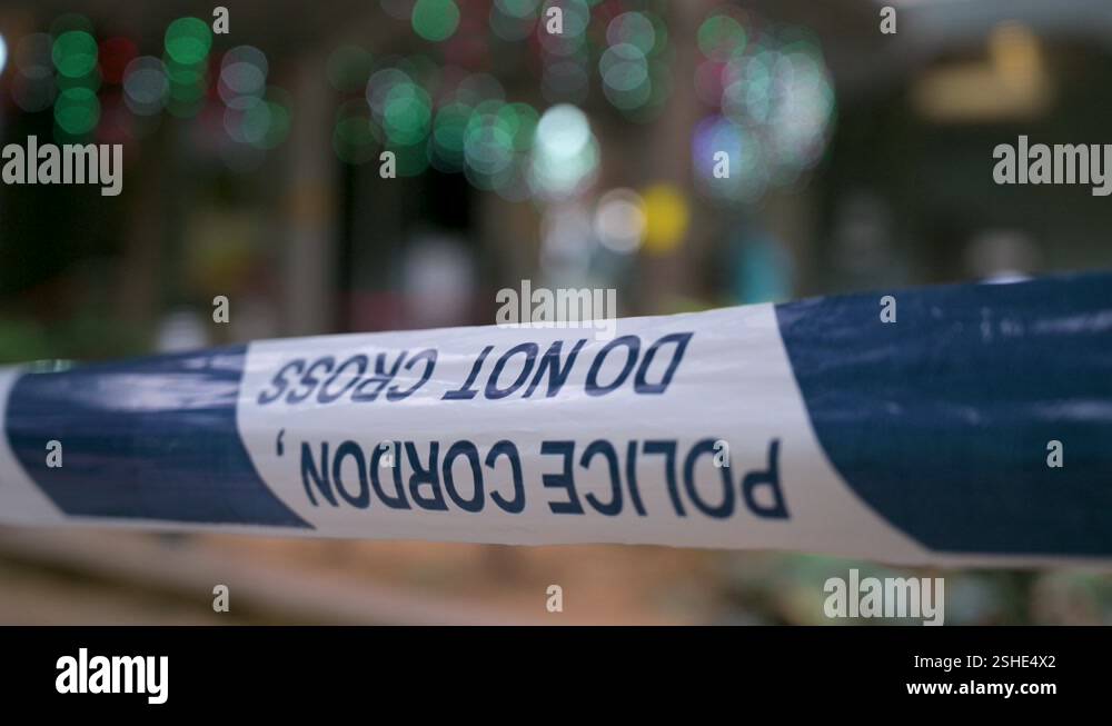 Police cordon tape is seen in the foreground as a neighborhood area is ...