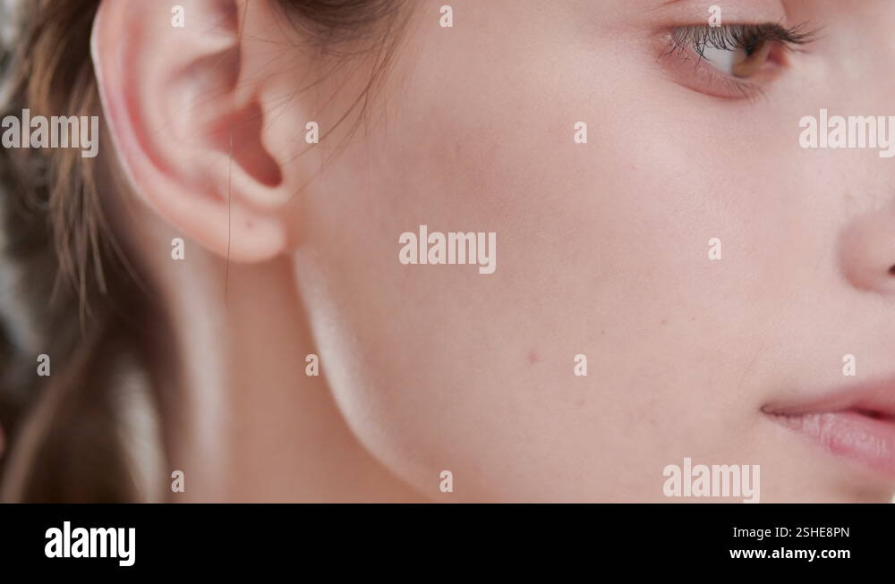 Extreme close-up of female model strokes jawline looking aside Stock ...