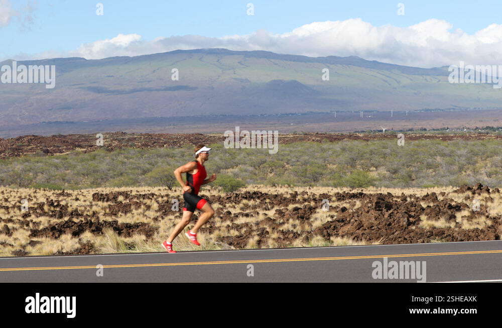 Runner man running in triathlon suit training for Iron man on Hawaii ...